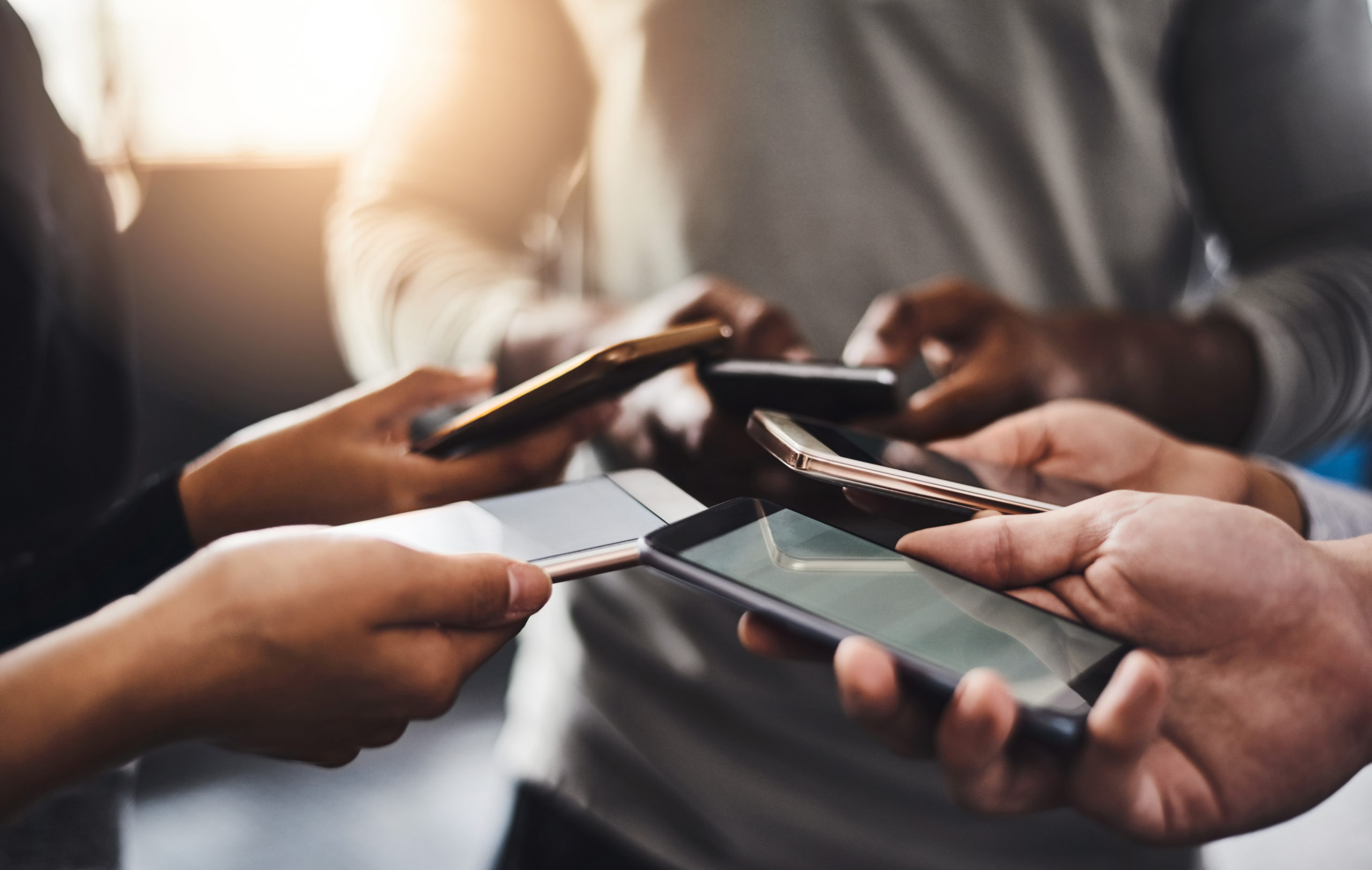 A_group_of_people_standing_close_together_each_holding_a_smartphone _in ...